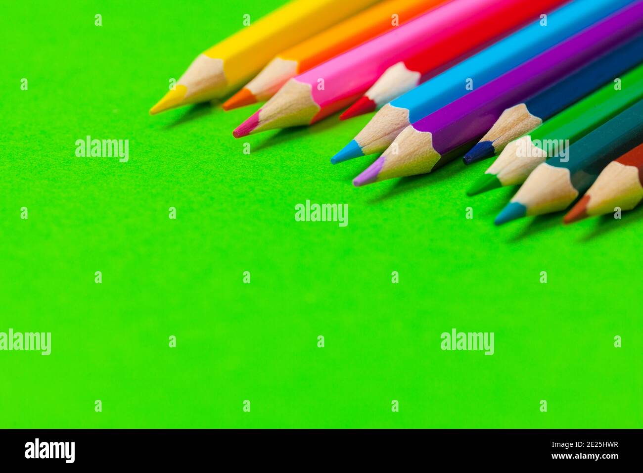 Colored pencils on bright color paper background Stock Photo - Alamy