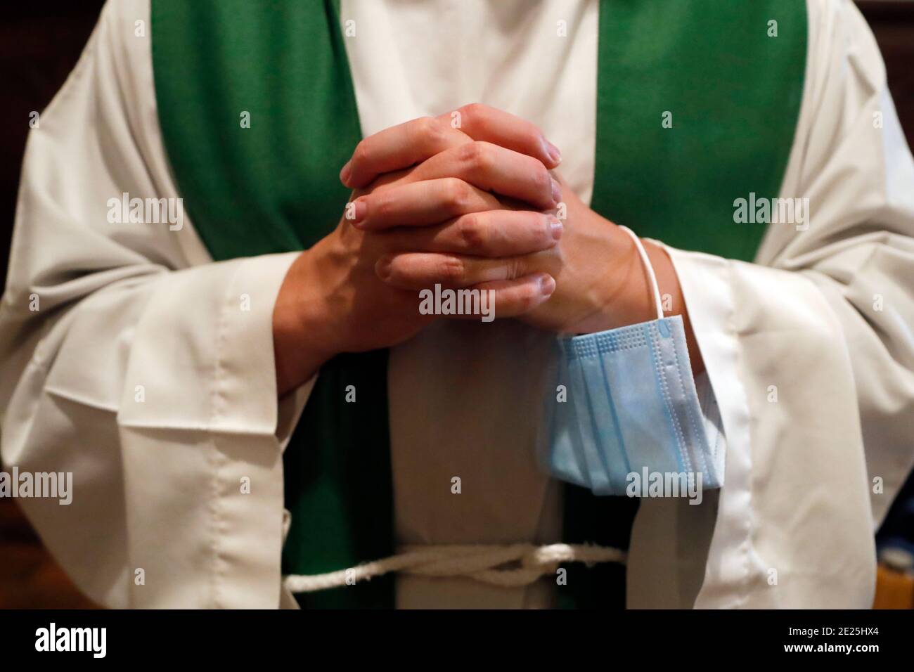 Priest praying with a surgical mask. Covid-19 Stock Photo - Alamy