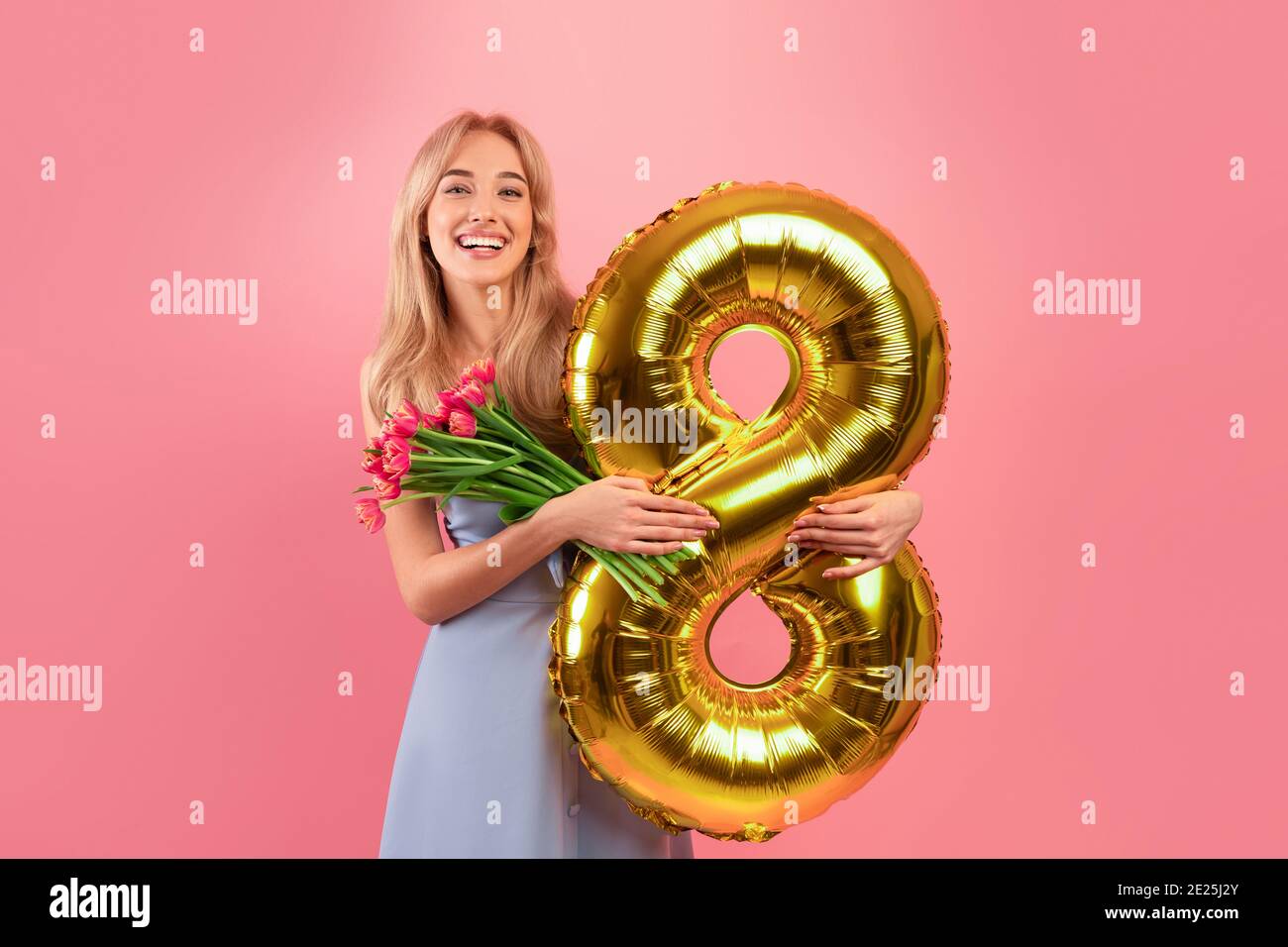 Charming millennial lady with spring flowers and gold balloon ...