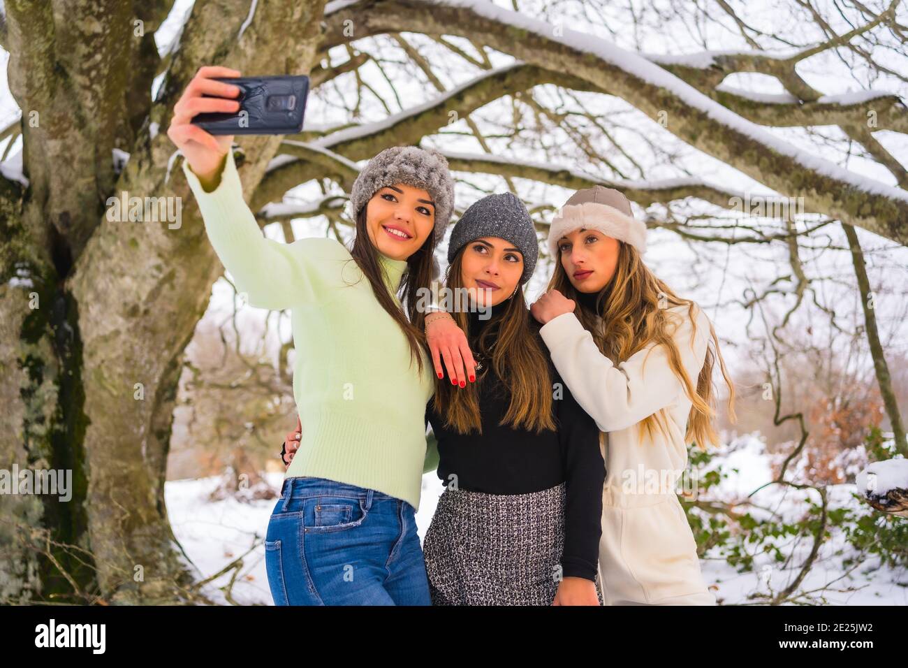 Female friends taking a selfie under a tree in winter Stock Photo - Alamy