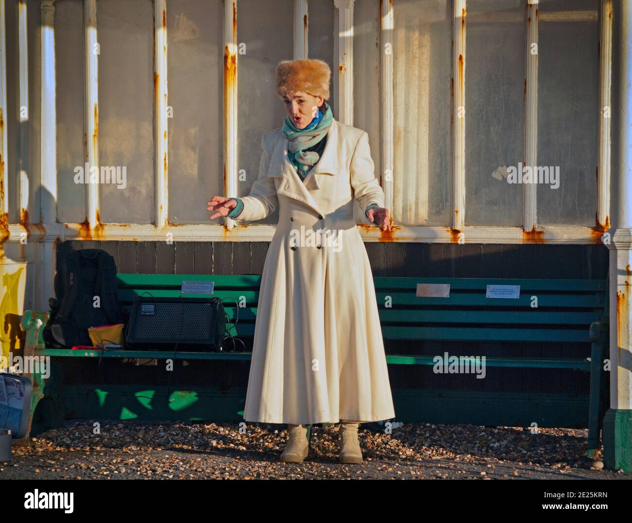 A female opera singer performs by a seafront shelter in Brighton Stock ...