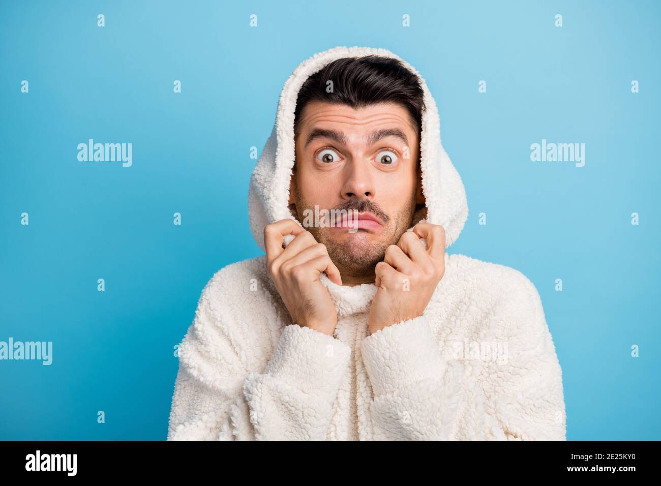 Photo portrait of scared man wearing woolen hoodie isolated on pastel ...