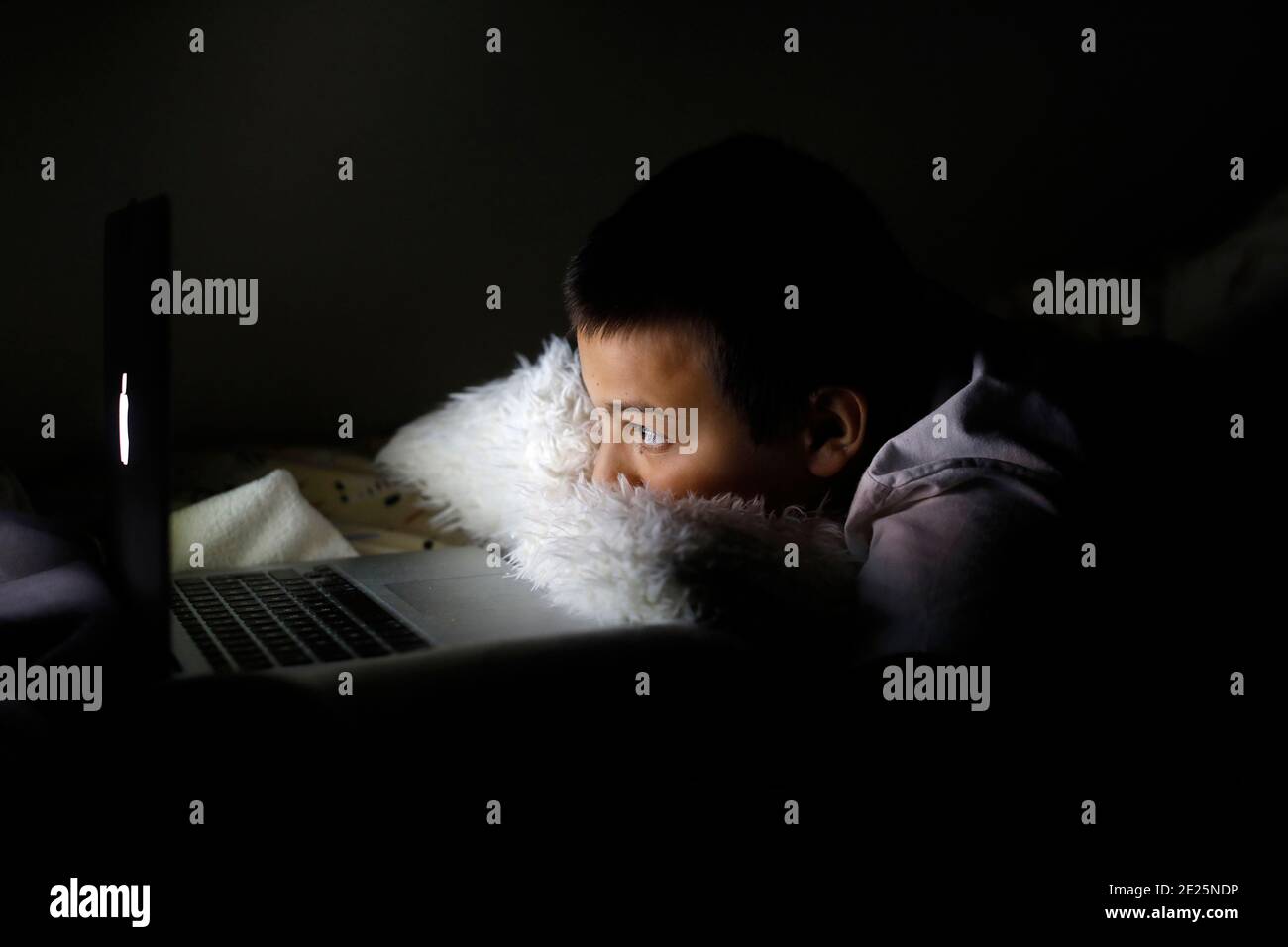 Boy staring at a computer screen at night in Montrouge, France Stock ...