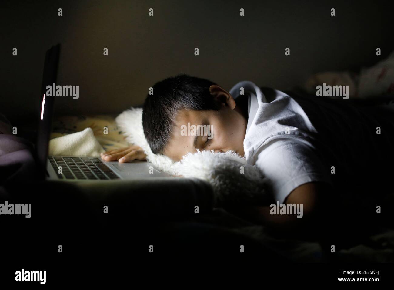 Boy falling asleep in front of a computer screen at night in Montrouge ...