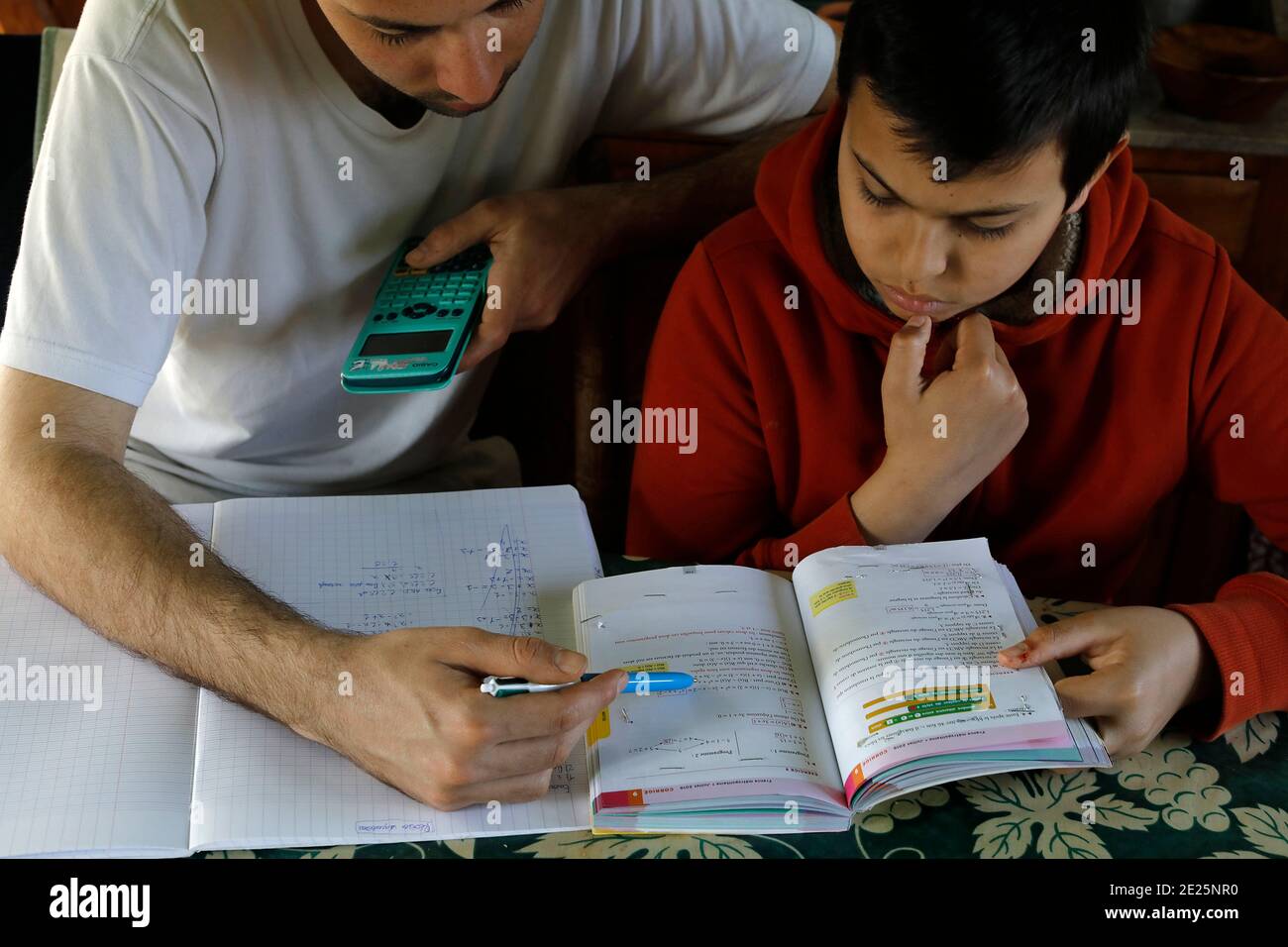 Young man helping his younger brother with his homework. Eure, France ...