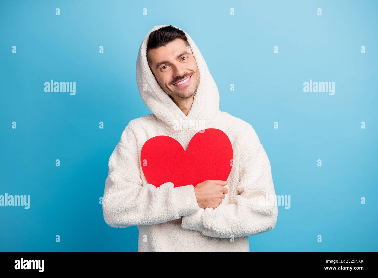 Photo portrait of guy hugging big red heart card wearing wool hoodie ...
