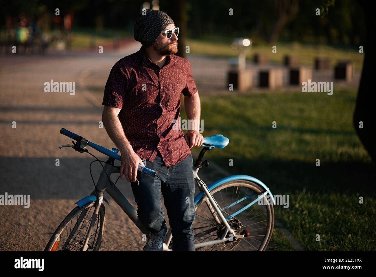 A handsome male with bicycle and backpack Stock Photo - Alamy