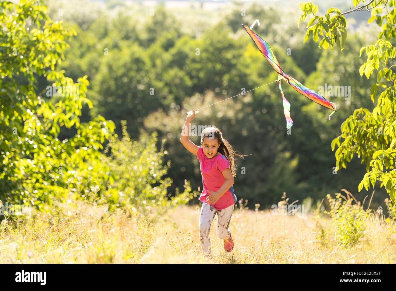 Little girl flying a kite running outdoor with a kite Stock Photo - Alamy