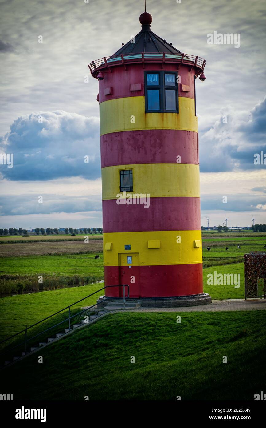 Vertical shot of the famous Pilsum Lighthouse on a dyke near the ...