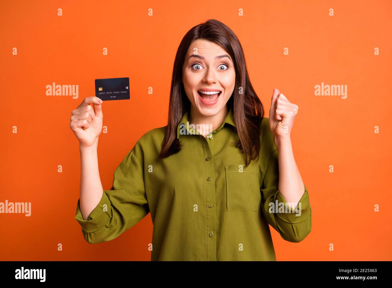 Photo of amazed young lady demonstrate debit card open mouth raise fist ...