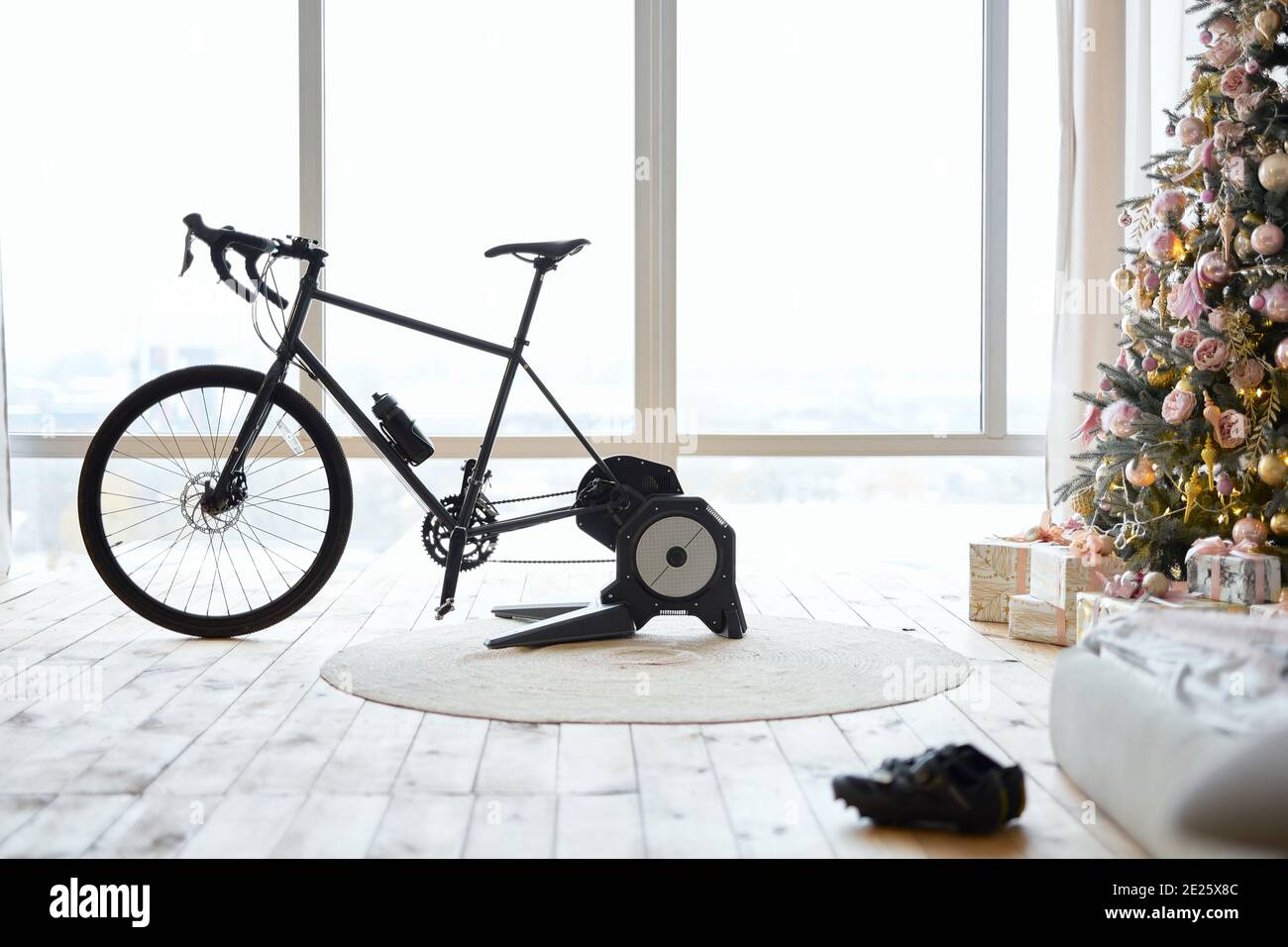 Black exercise bicycle or stationery bike in room with large windows ...