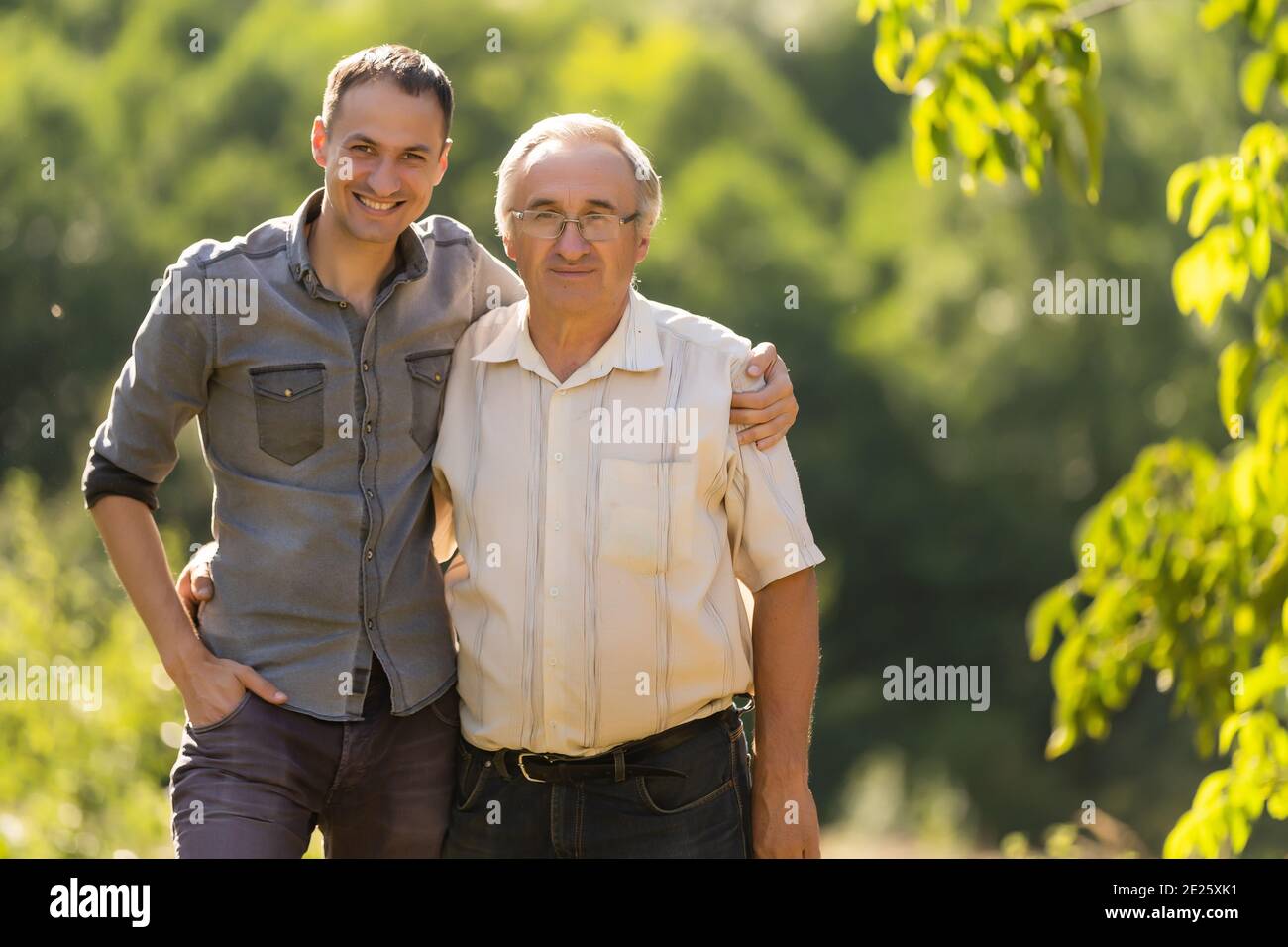 Portrait of a smiling father with adult son at the park Stock Photo - Alamy