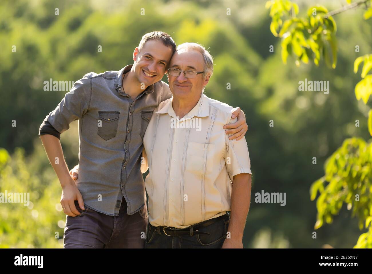 Portrait of a smiling father with adult son at the park Stock Photo - Alamy