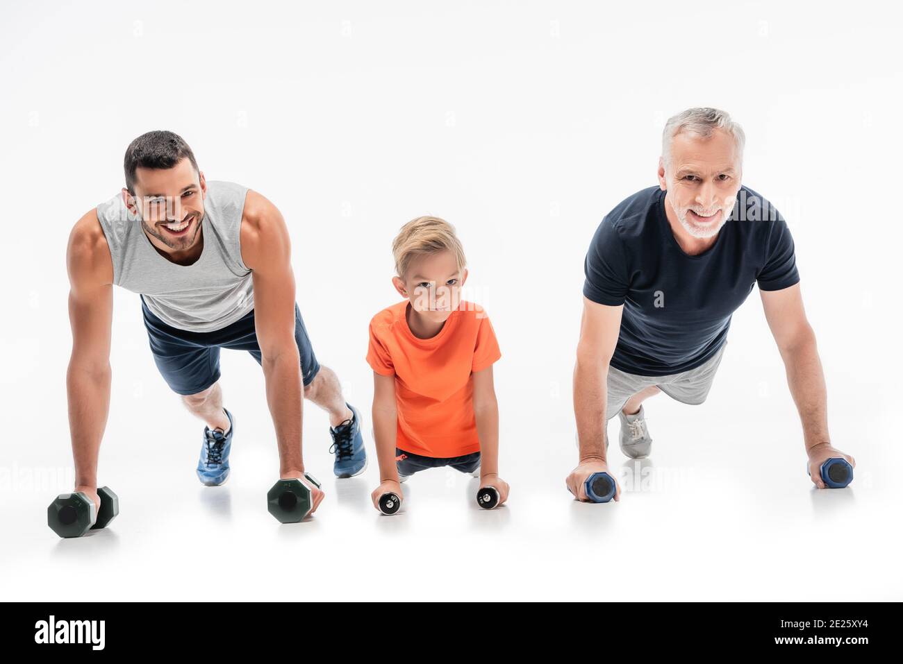 cheerful boy with grandfather and dad doing push ups exercise with ...