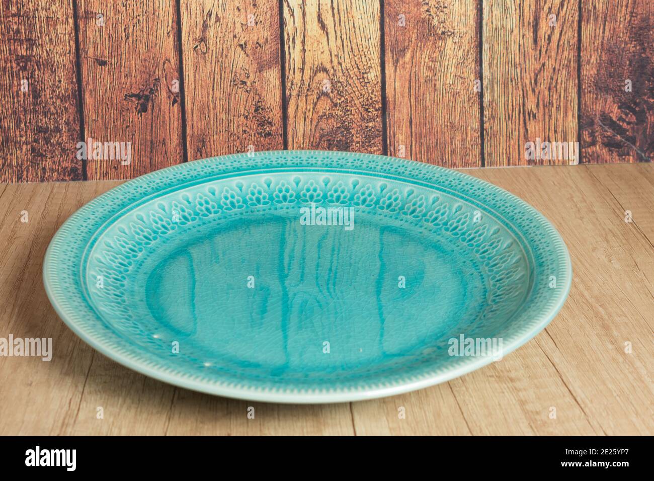 Empty vintage turquoise plate on wooden table. lateral view Stock Photo ...