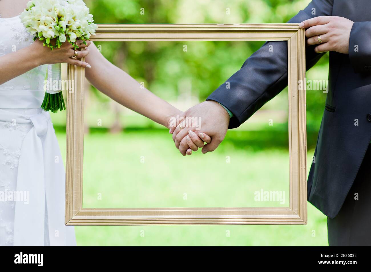 Young married couple holding hands through the frame Stock Photo - Alamy