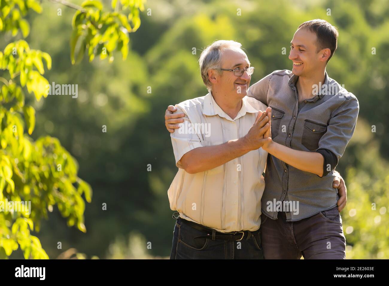 Portrait of a smiling father with adult son at the park Stock Photo - Alamy