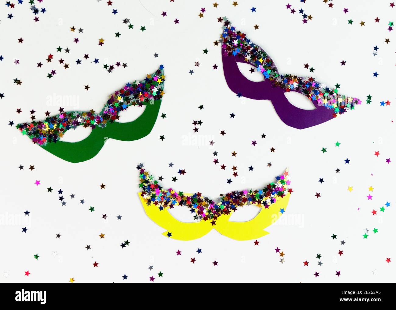 DIY colored Mardi Gras mask. Workplace with colored paper, feathers ...