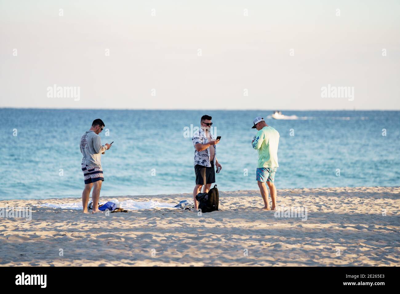 Guys on phones at the beach Stock Photo - Alamy
