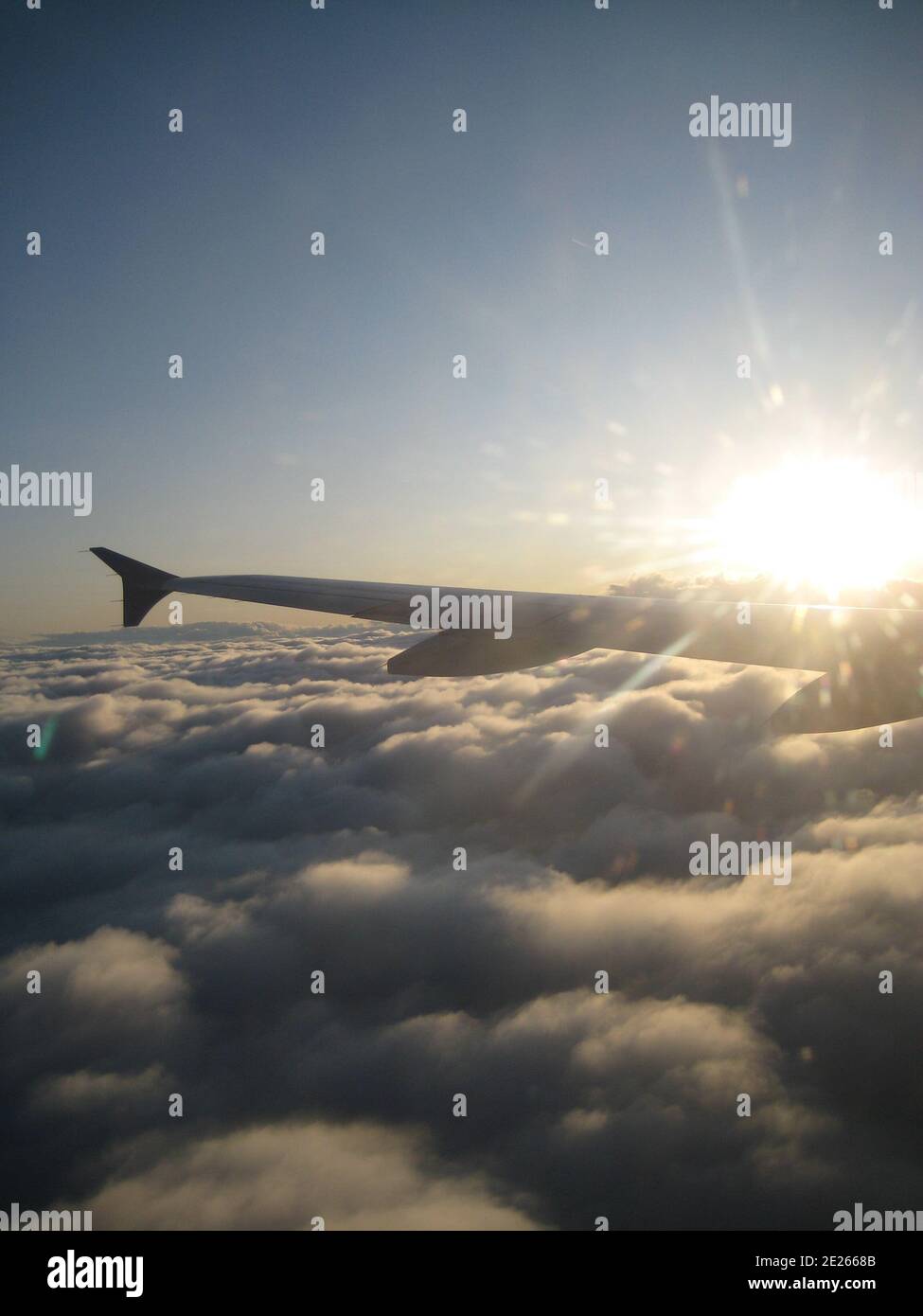 sunset between clouds from above out of a plane window Stock Photo - Alamy