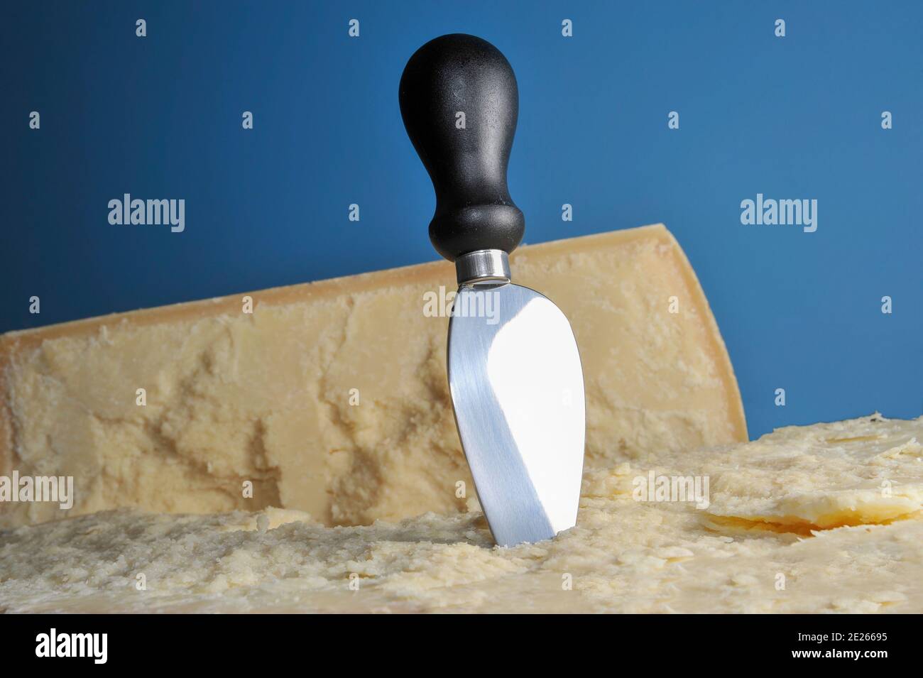 Parmesan knife with the typical drop shape, planted in the open form of ...