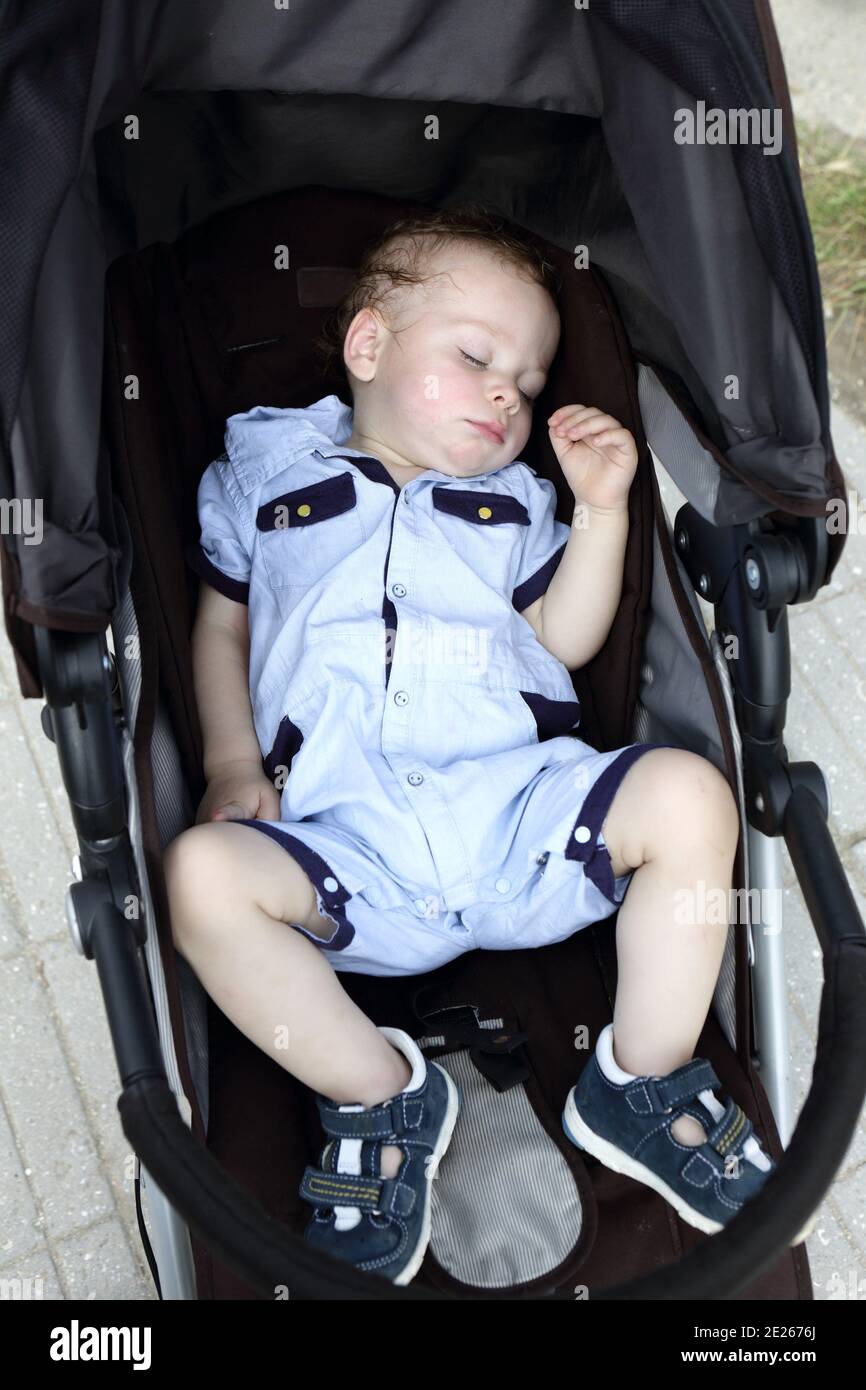Toddler sleeping in a stroller in summer Stock Photo - Alamy