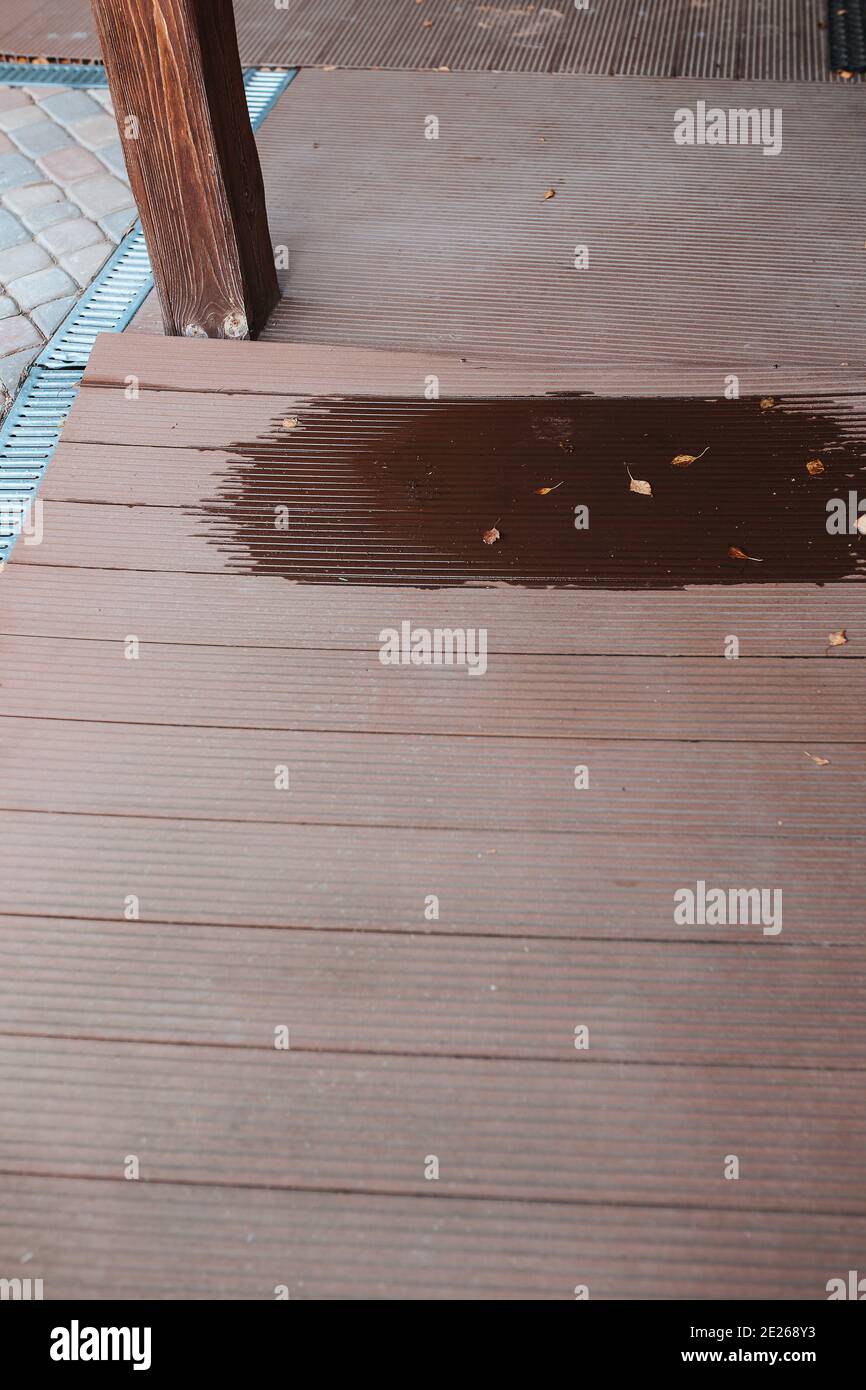A puddle on a terrace board after rain - bent over from moisture Stock ...
