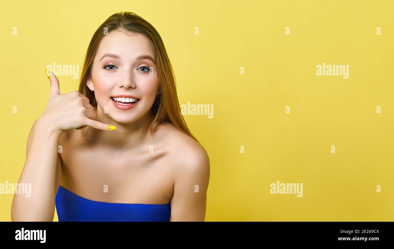 Smiling young woman gesturing to represent a telephone conversation ...