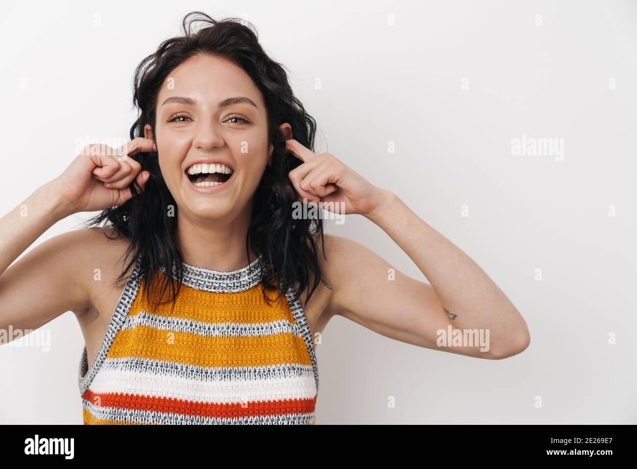 Beautiful young laughing woman posing isolated over white wall ...