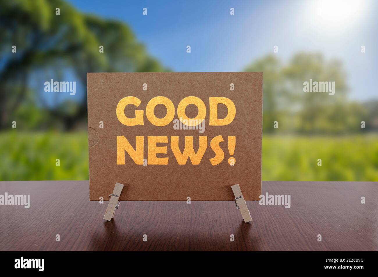 Good news text on card on the table with sunny green park background ...