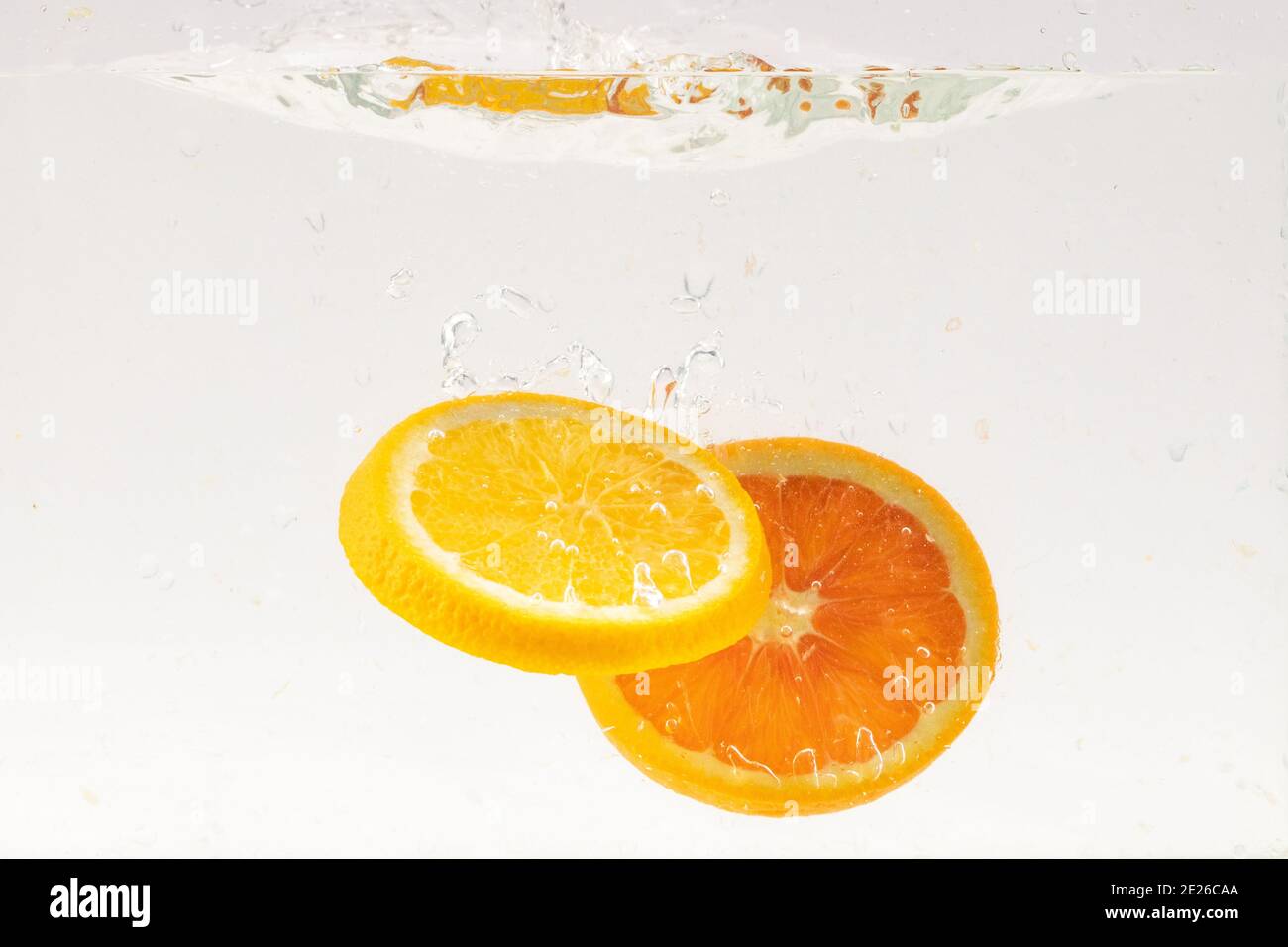 And orange slices floating in water on white background Stock Photo - Alamy