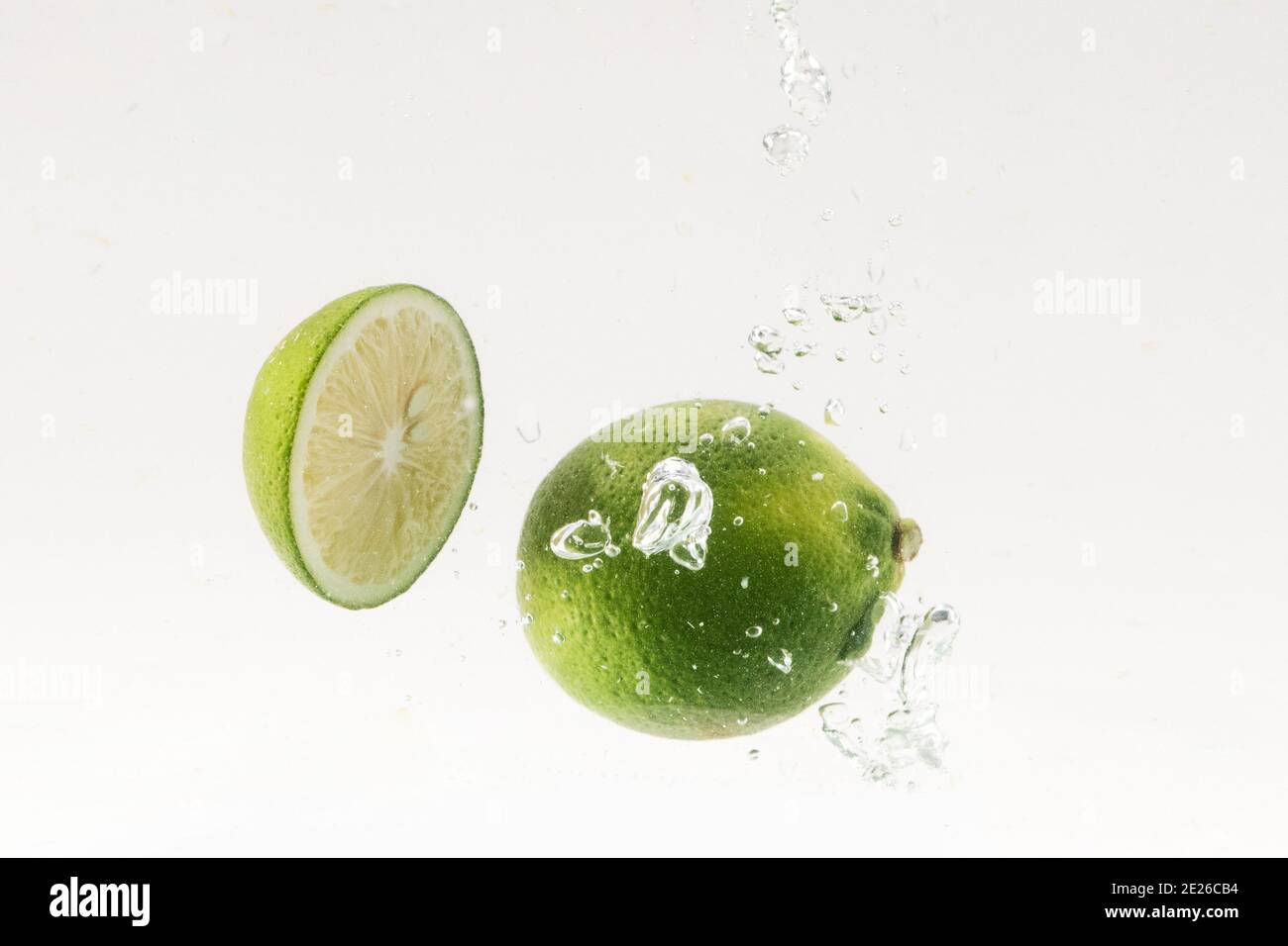 Lime floating in bubbling water on white background Stock Photo - Alamy