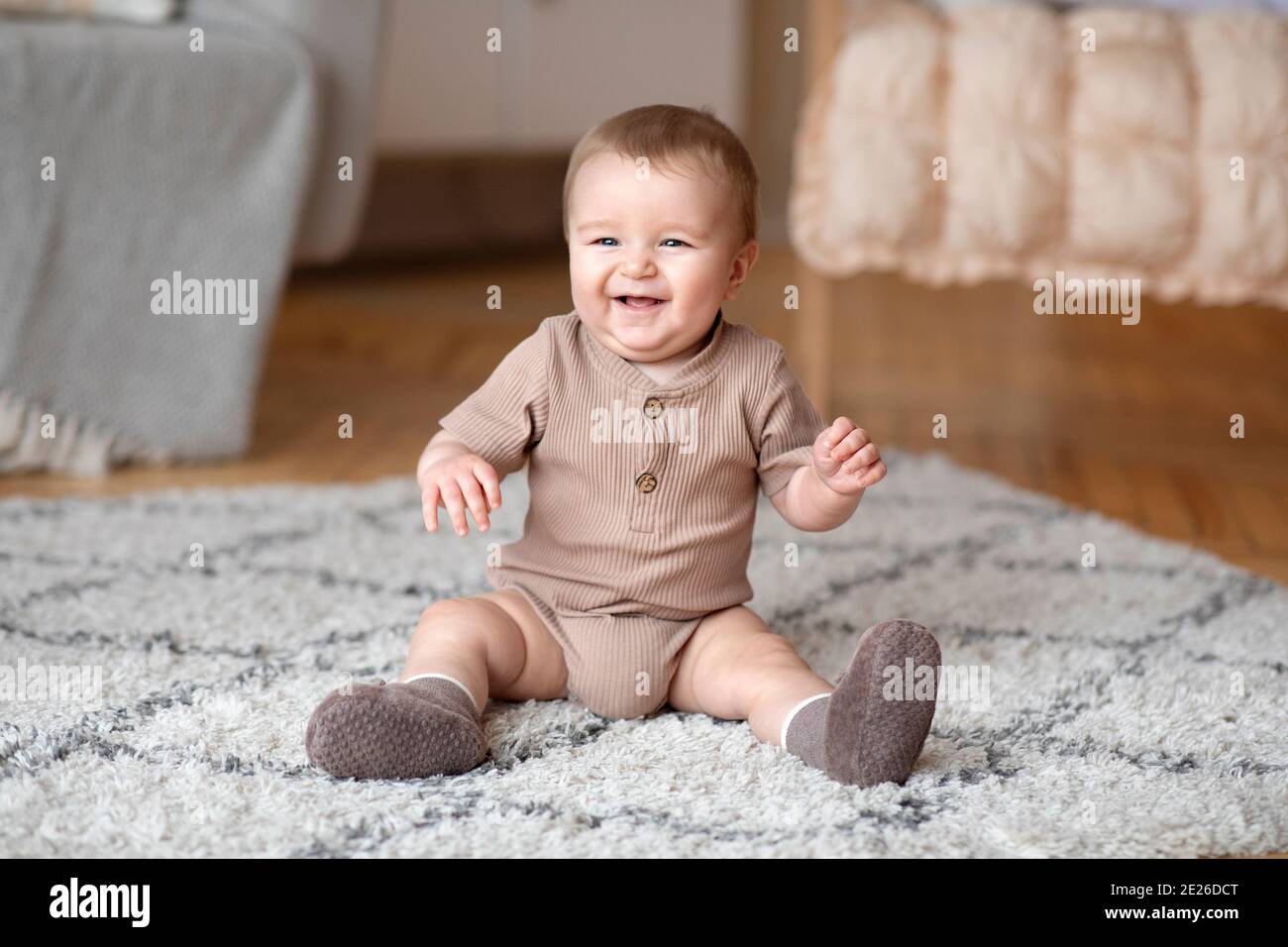 Happy little baby boy sitting on carpet at home Stock Photo - Alamy