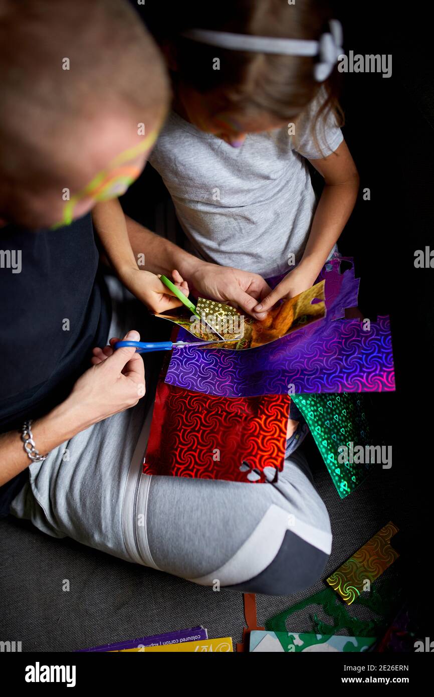 Daughter and father having fun making craft together at home on the ...