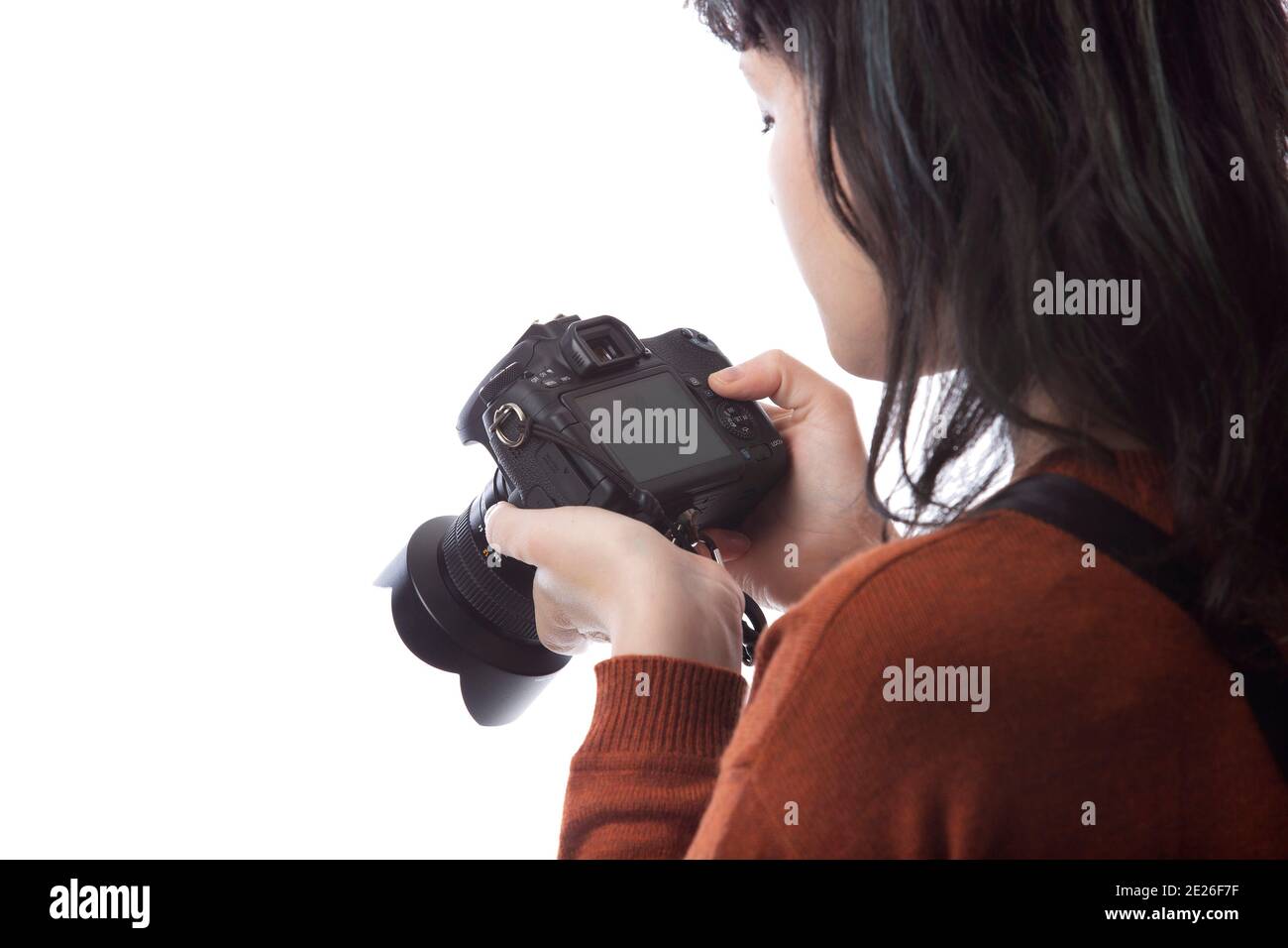 Side view of a female photographer holding a camera isolated on a white ...