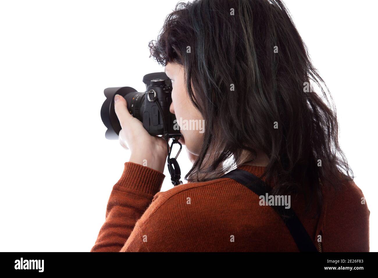 Side view of a female photographer holding a camera isolated on a white ...