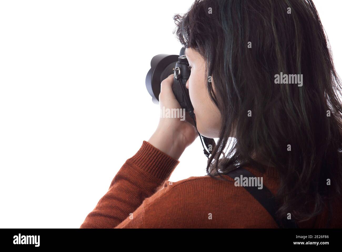 Side view of a female photographer holding a camera isolated on a white ...