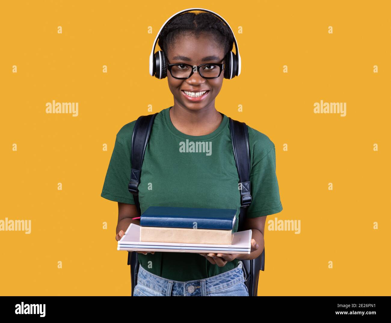 Happy female student headphones holding hi-res stock photography and ...