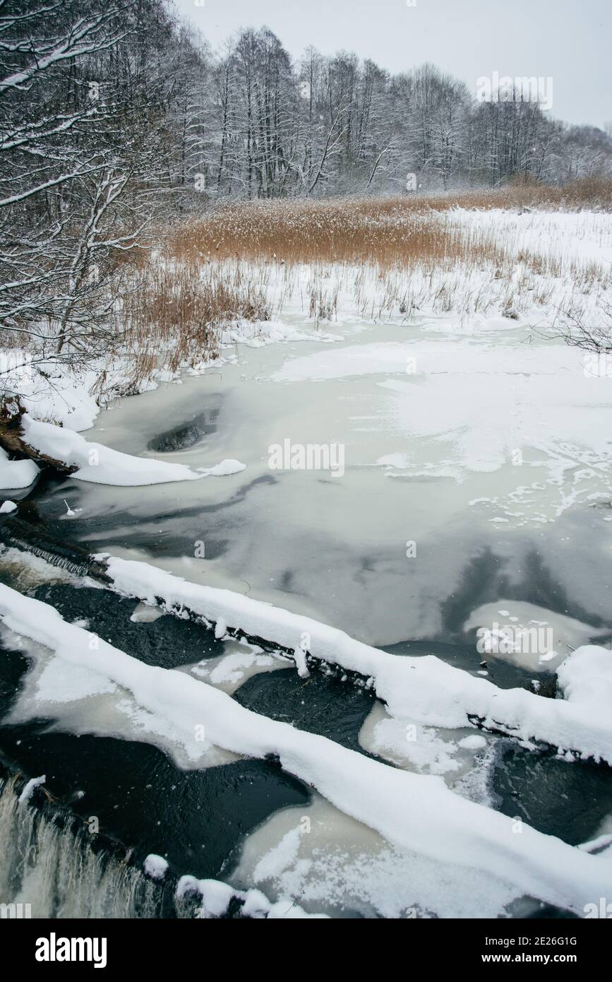 winter reservoir with a small waterfall, only the waterfall remained ...