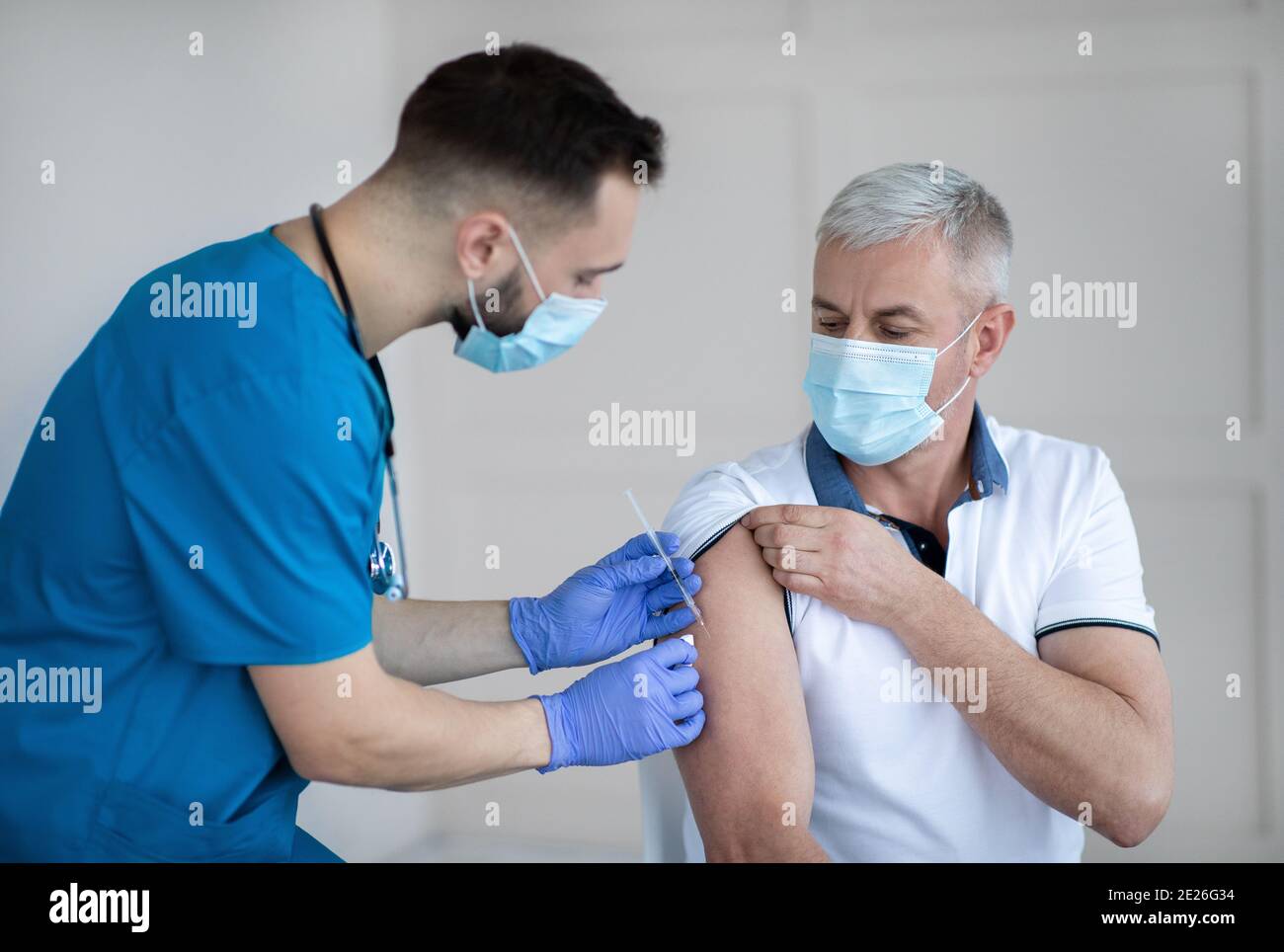 Doctor giving injection male patient hi-res stock photography and ...