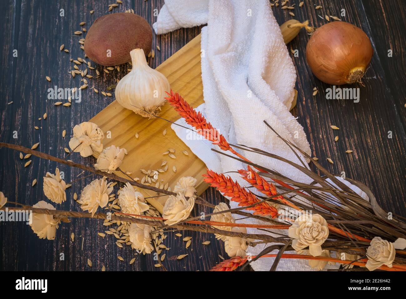 Top view of onions, garlic, cutting board, dishcloth, barley, and dried ...