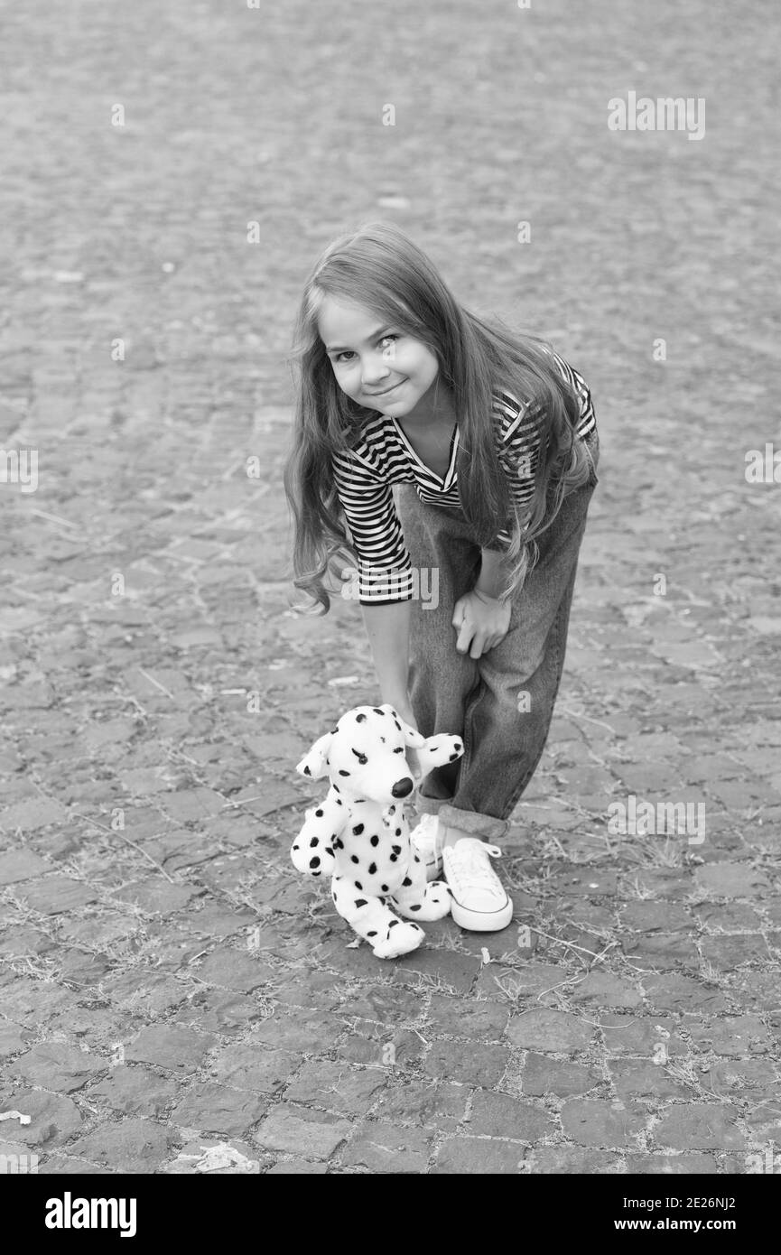 Play is simple joy. Happy baby play with toy dog outdoors. Child ...
