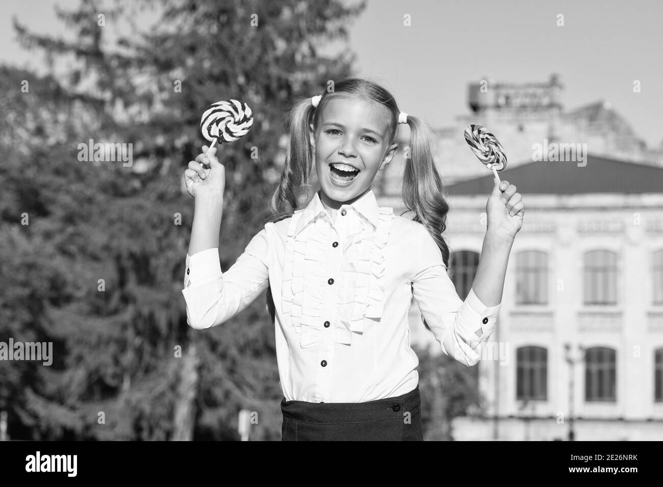 Happy student girl eat colorful lollipop outdoors, carefree childhood ...