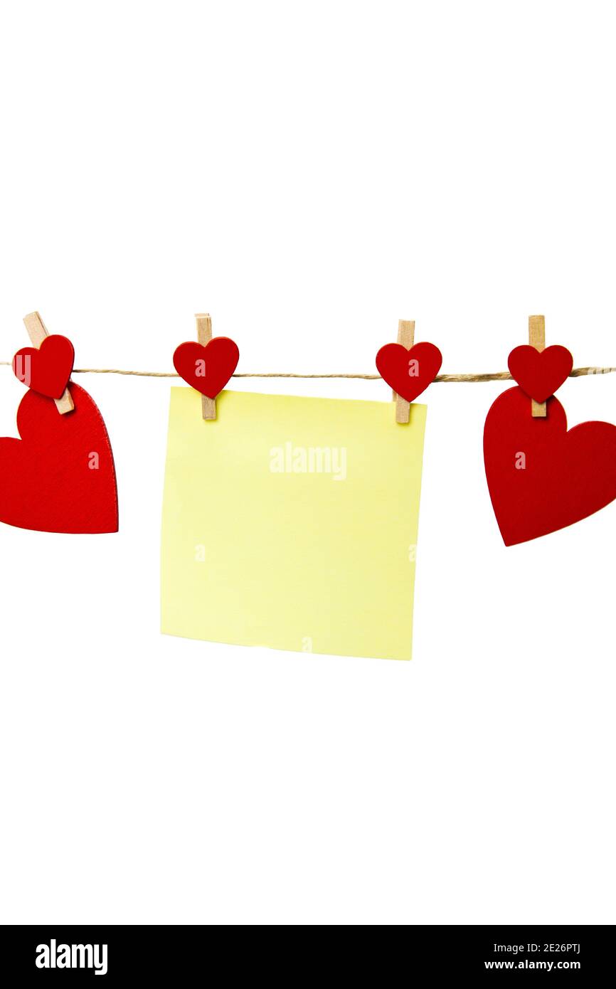 Blank yellow sticky note hanging with red hearts isolated on white ...
