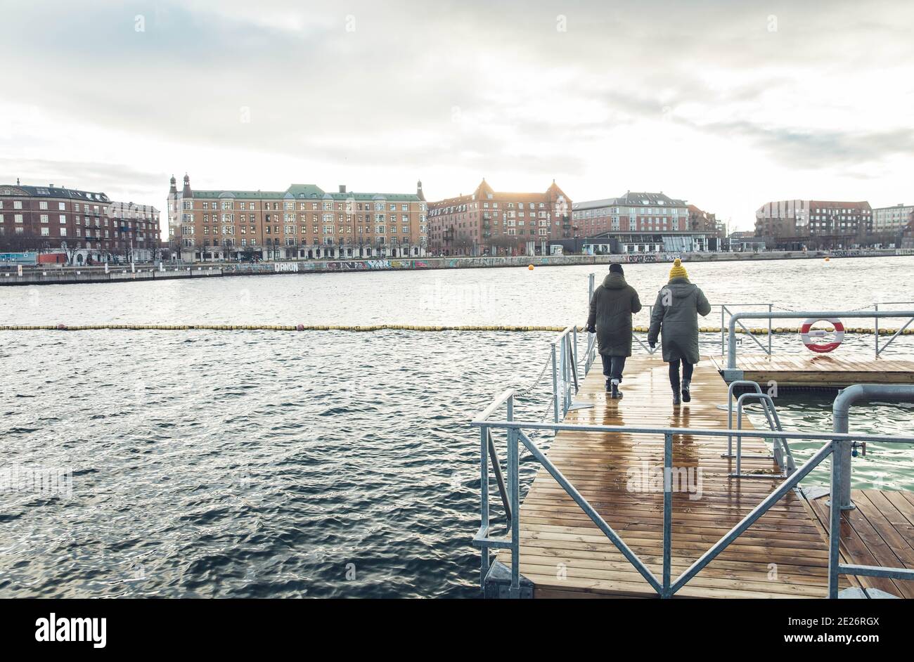 Two people walking on dock with winter coats hi-res stock photography ...