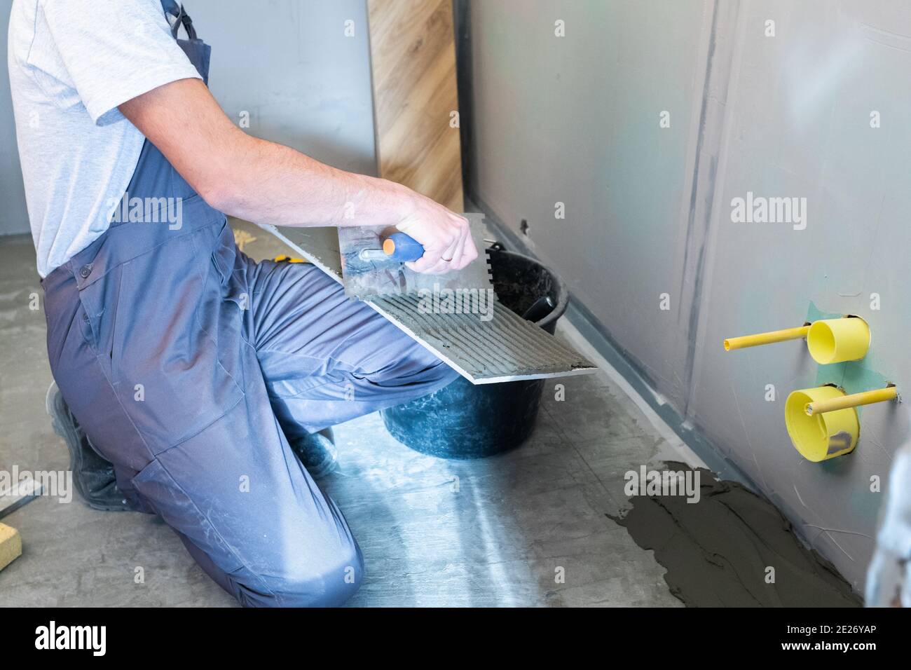 The process of laying ceramic floor tiles with a herringbone pattern ...
