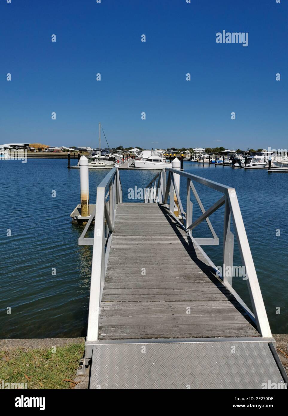 Vertical shot of a small pier in the marina, docked boats in the ...