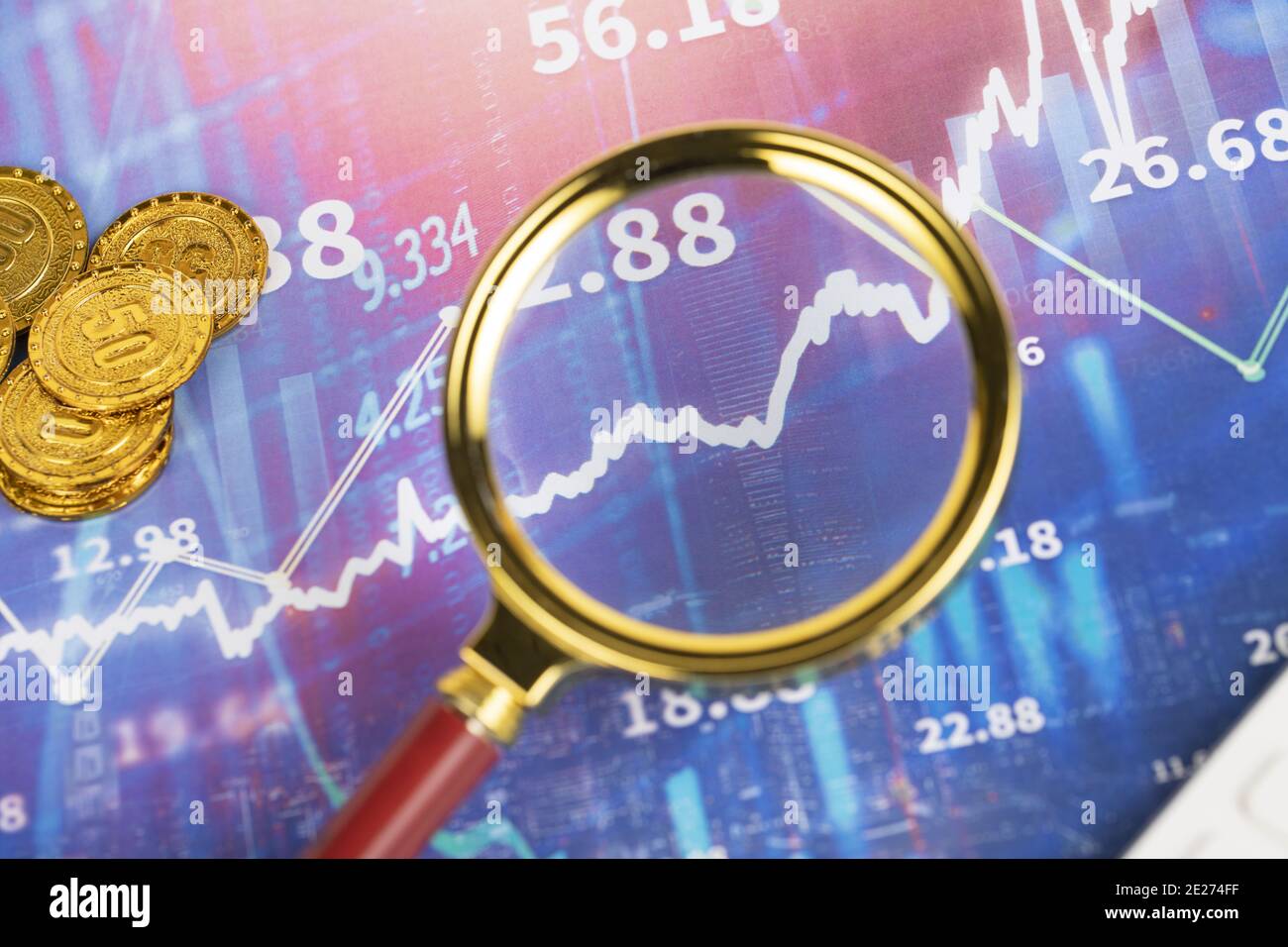 Magnifier and gold coins on stock market chart Stock Photo - Alamy