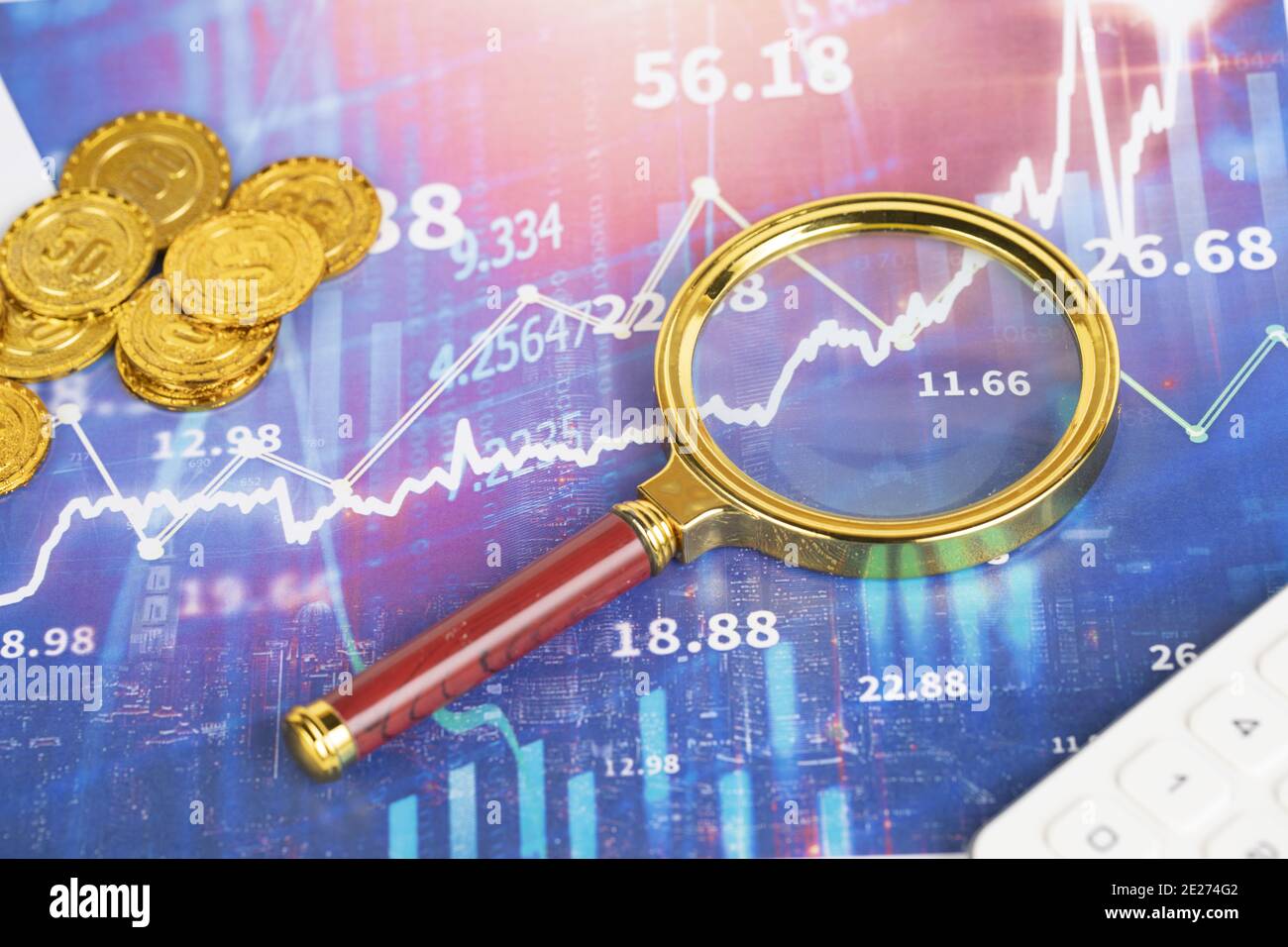 Magnifier and gold coins on stock market chart Stock Photo - Alamy