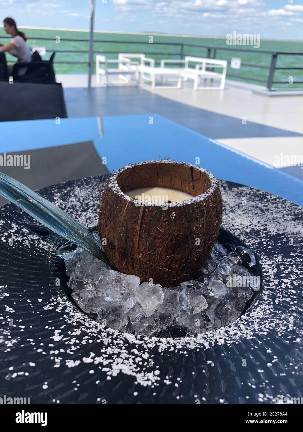 Exotic dessert in a coconut shell in black dish with ice, restaurant by ...